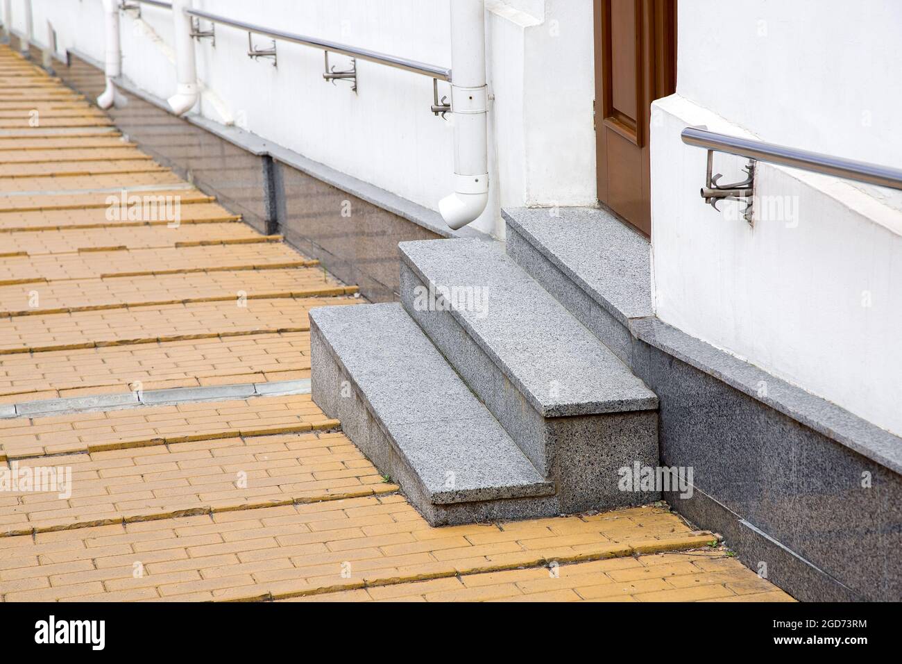 granite threshold at entrance door made of brown wood and white facade ...