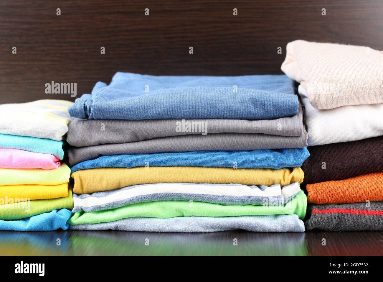 Stack of colorful clothes, on dark background Stock Photo - Alamy