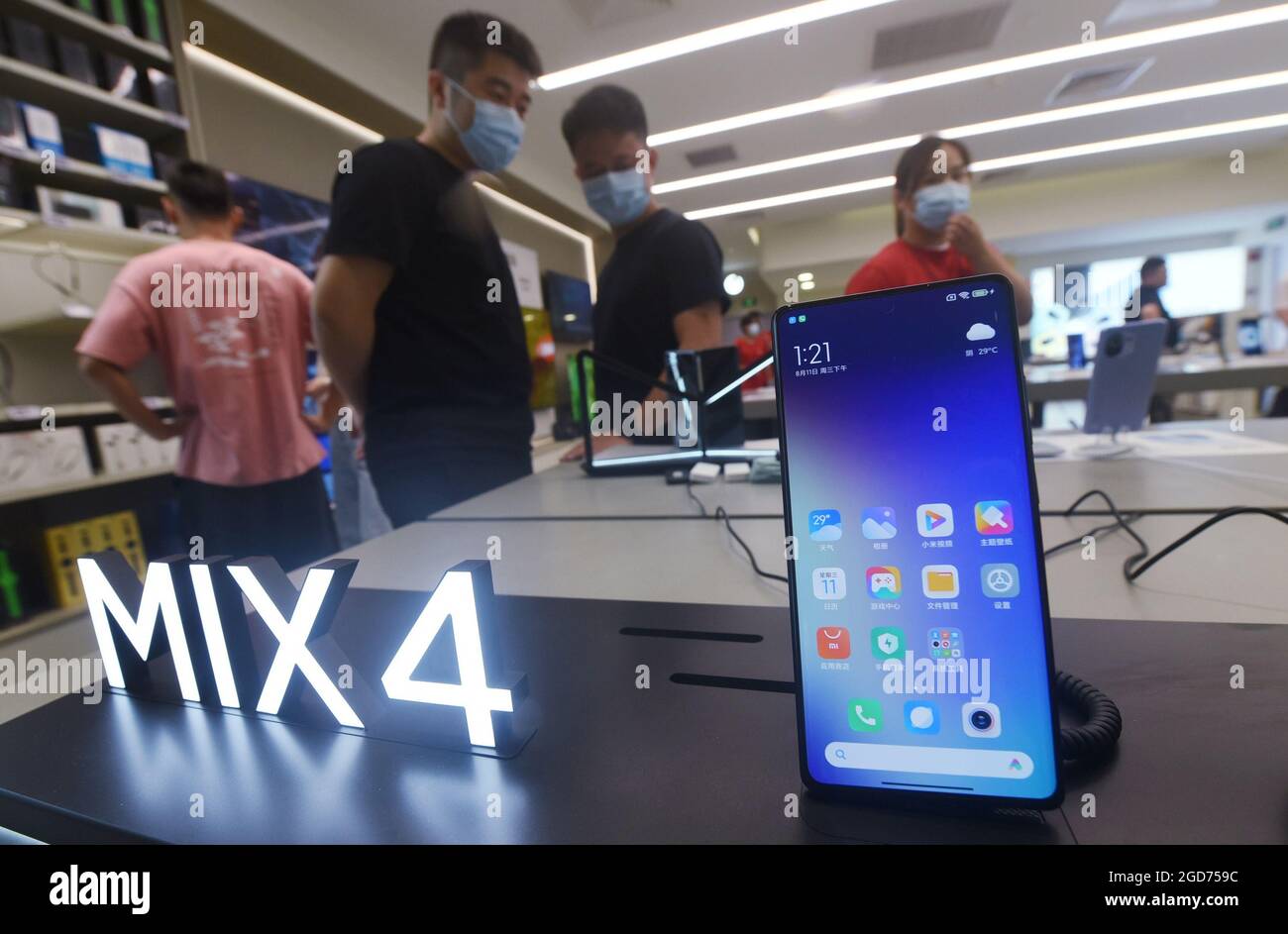 People experience the newly-released MIX4 mobile phones in a Xiaomi flagship store in Hangzhou ...