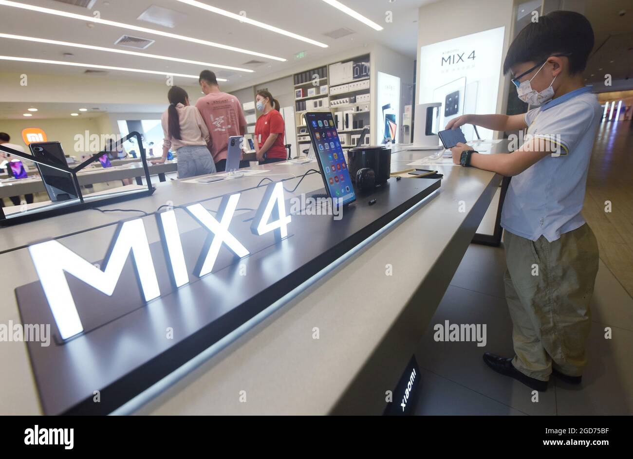 People experience the newly-released MIX4 mobile phones in a Xiaomi flagship store in Hangzhou ...