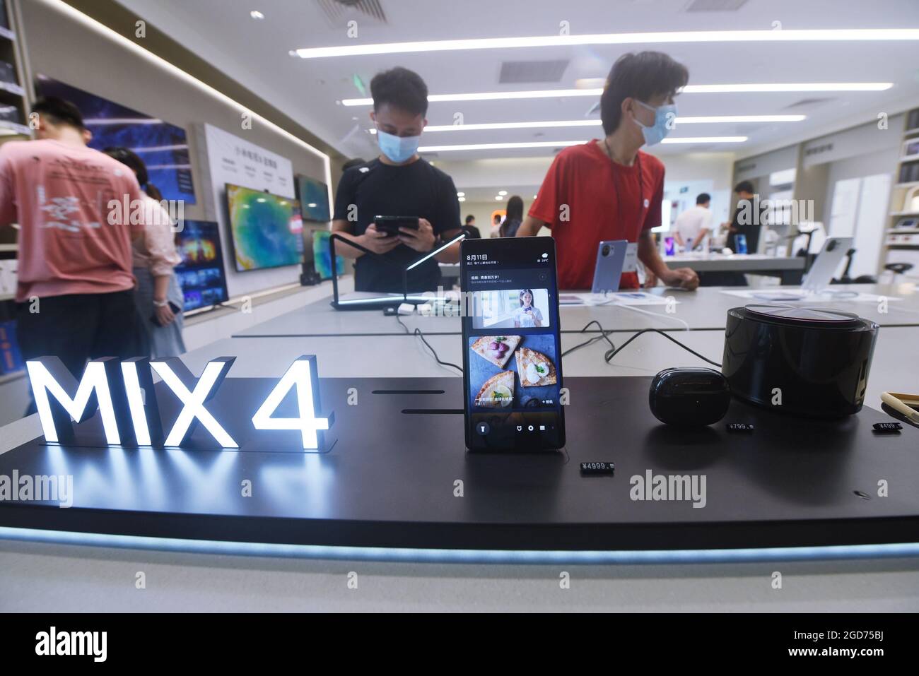 People experience the newly-released MIX4 mobile phones in a Xiaomi flagship store in Hangzhou ...