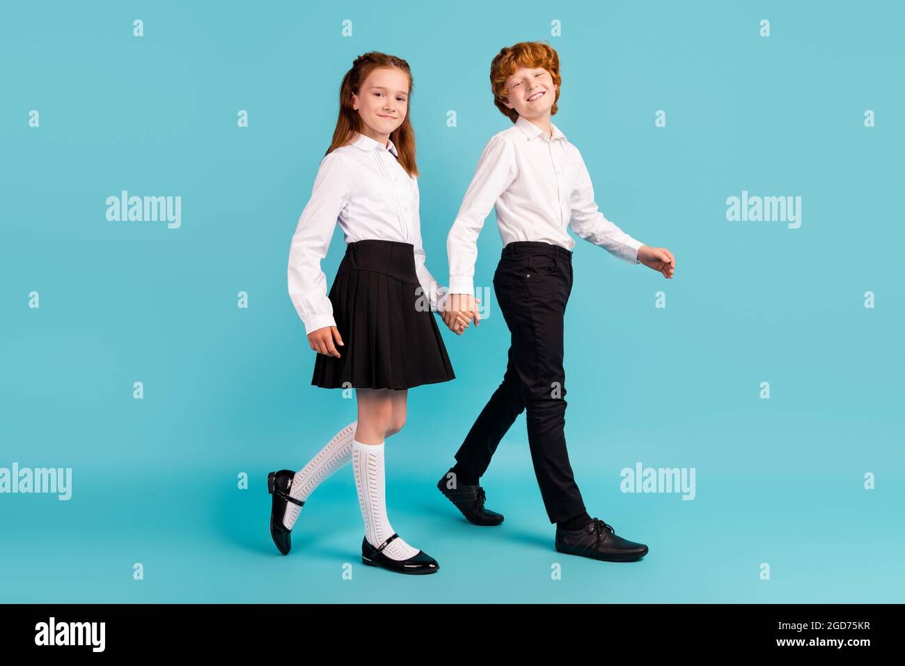 Full length body size profile side view of two nice cheerful kids going ...