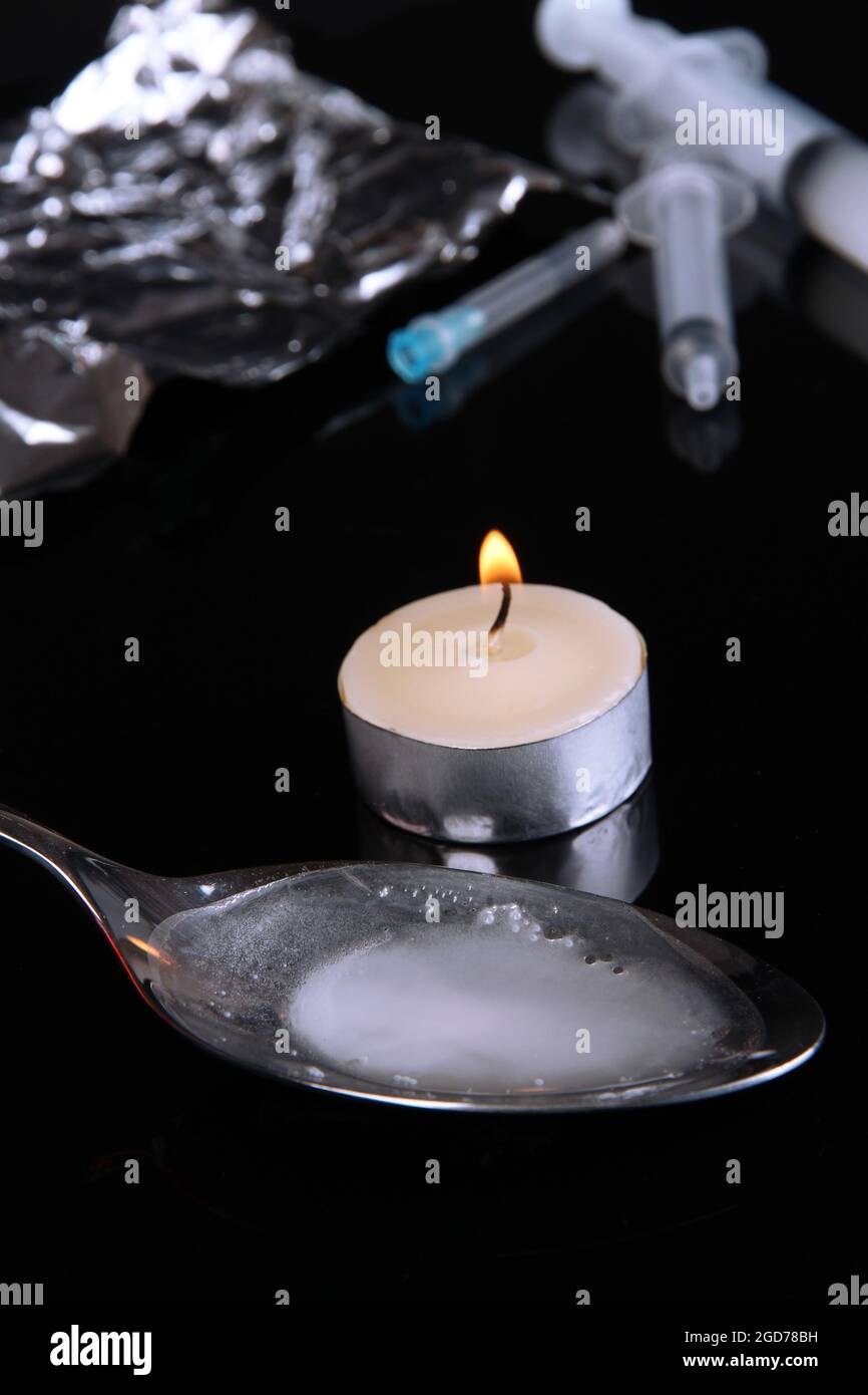 Heroin in spoon on black background Stock Photo - Alamy