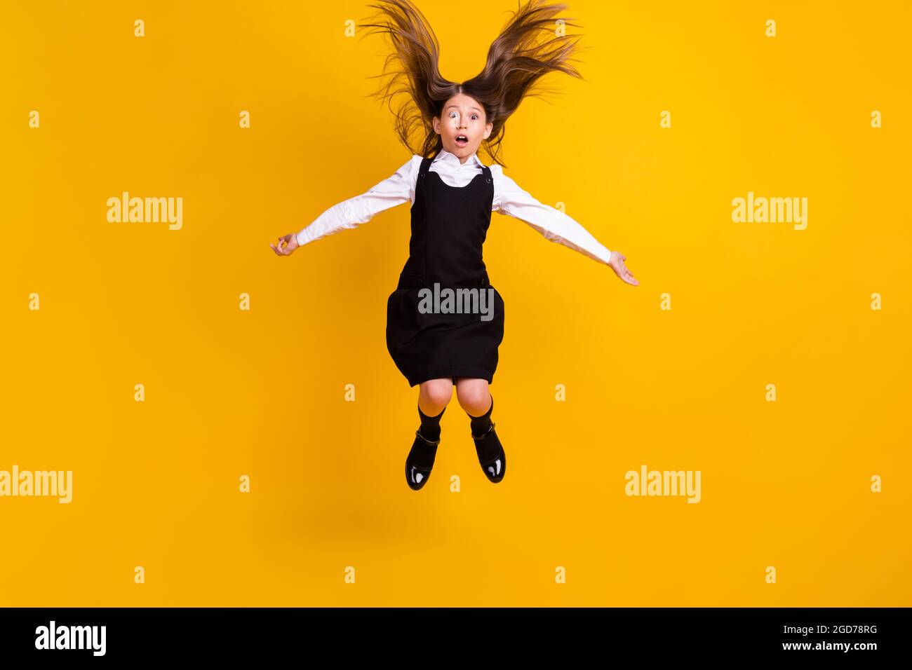 Full length photo of amazed shocked crazy girl jump up fly hair back to ...