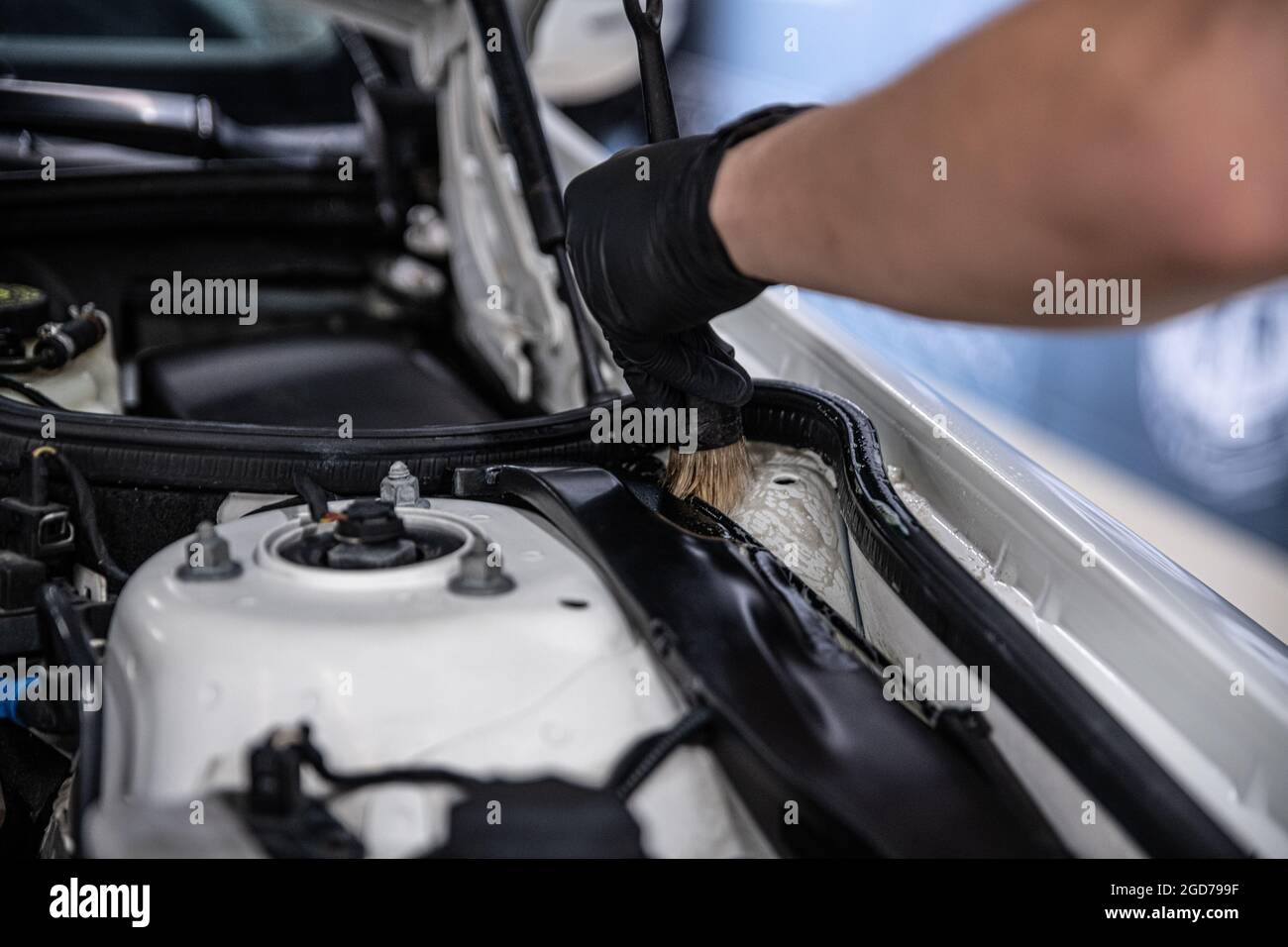 Car detailing studio employee cleans the engine compartment Stock Photo ...
