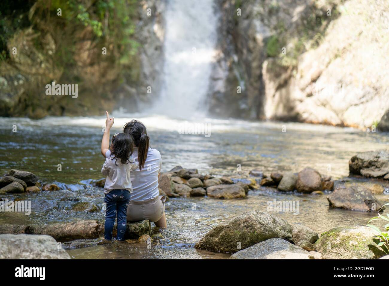Cute mom spending time with her daughter near a waterfall Stock Photo ...
