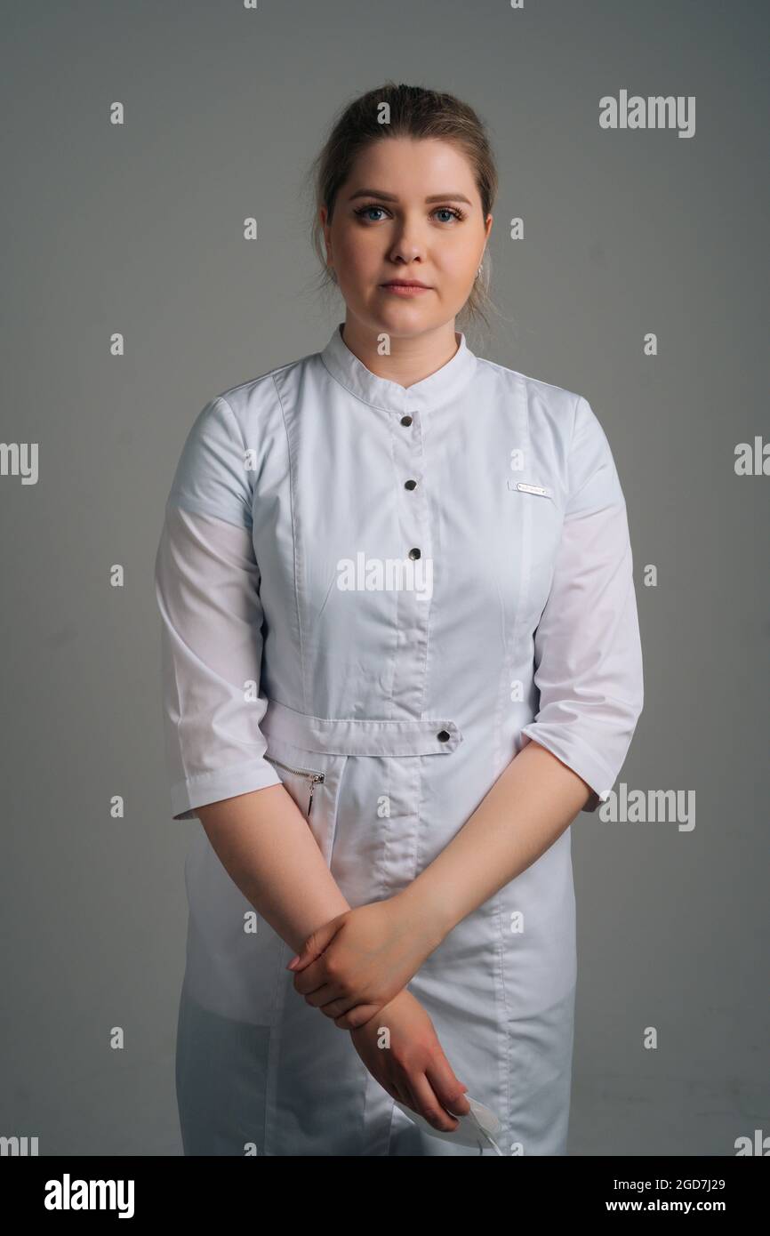 Full length portrait of serious young female doctor wearing medical ...