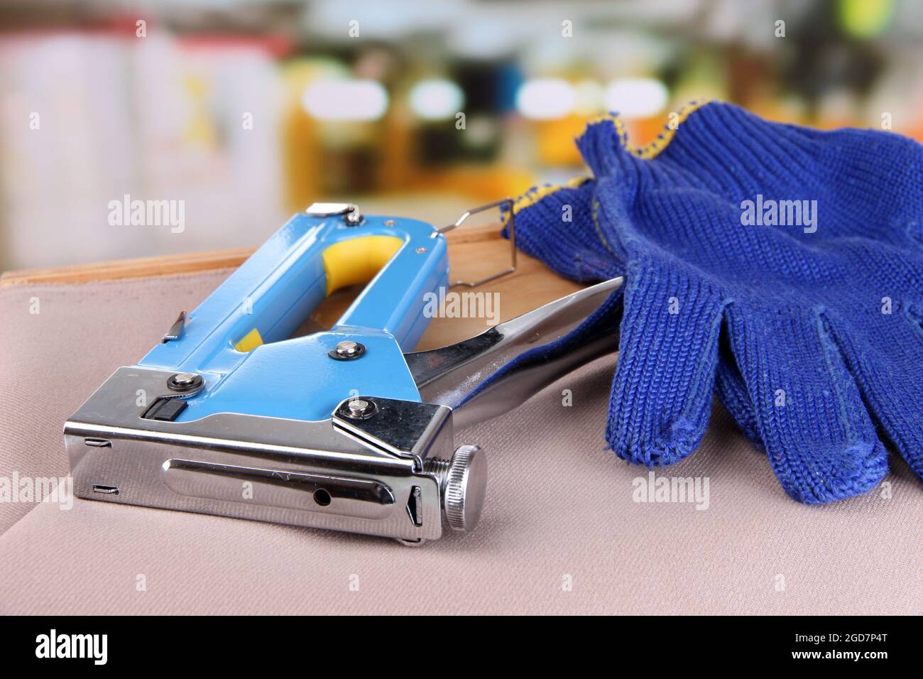 Construction stapler and gloves on fabric on bright background Stock ...