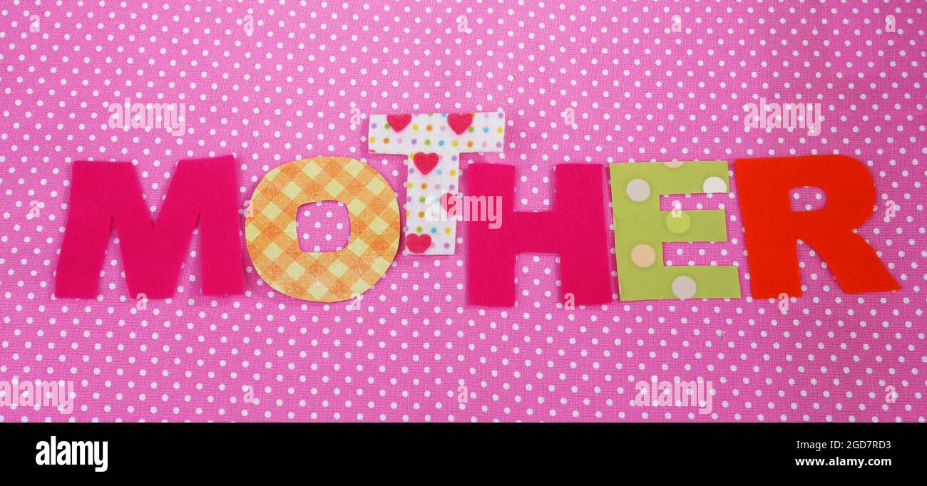 Mother- lettering of handmade paper letters on pink polka background ...