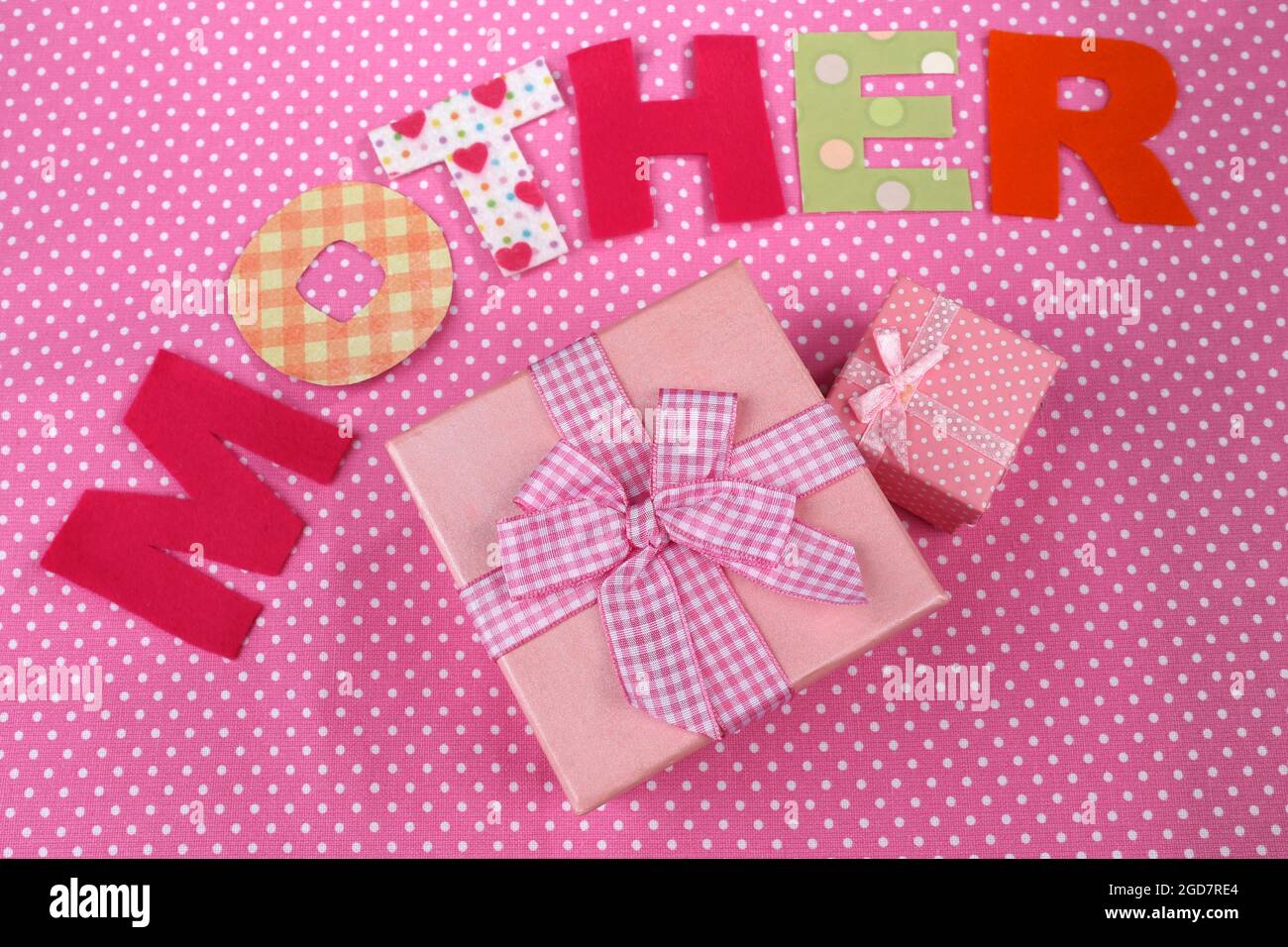 Mother- lettering of handmade paper letters on pink polka background ...