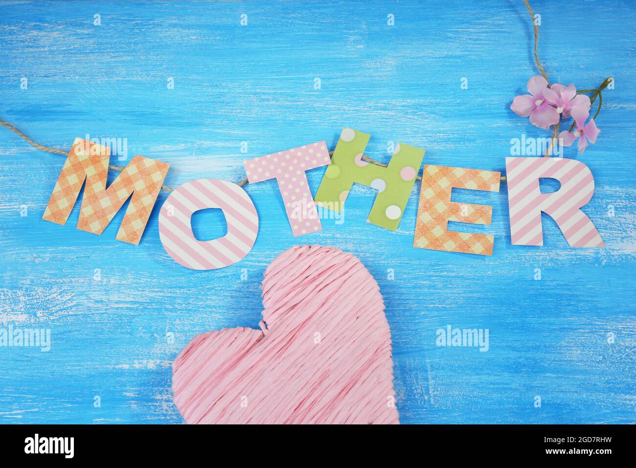 Mother- lettering of handmade paper letters on blue wooden background ...