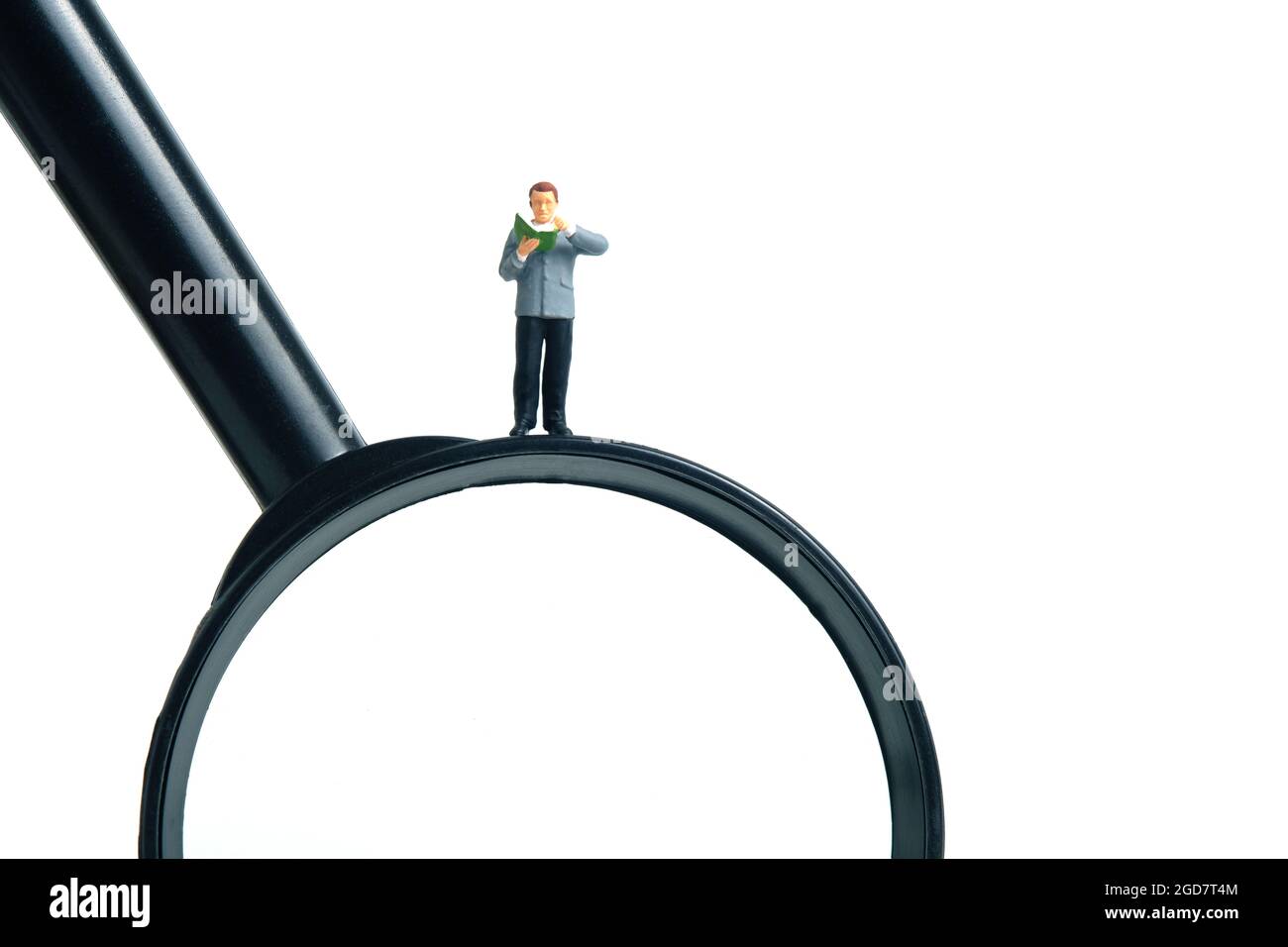 Miniature people toy figure photography. A men student standing above ...