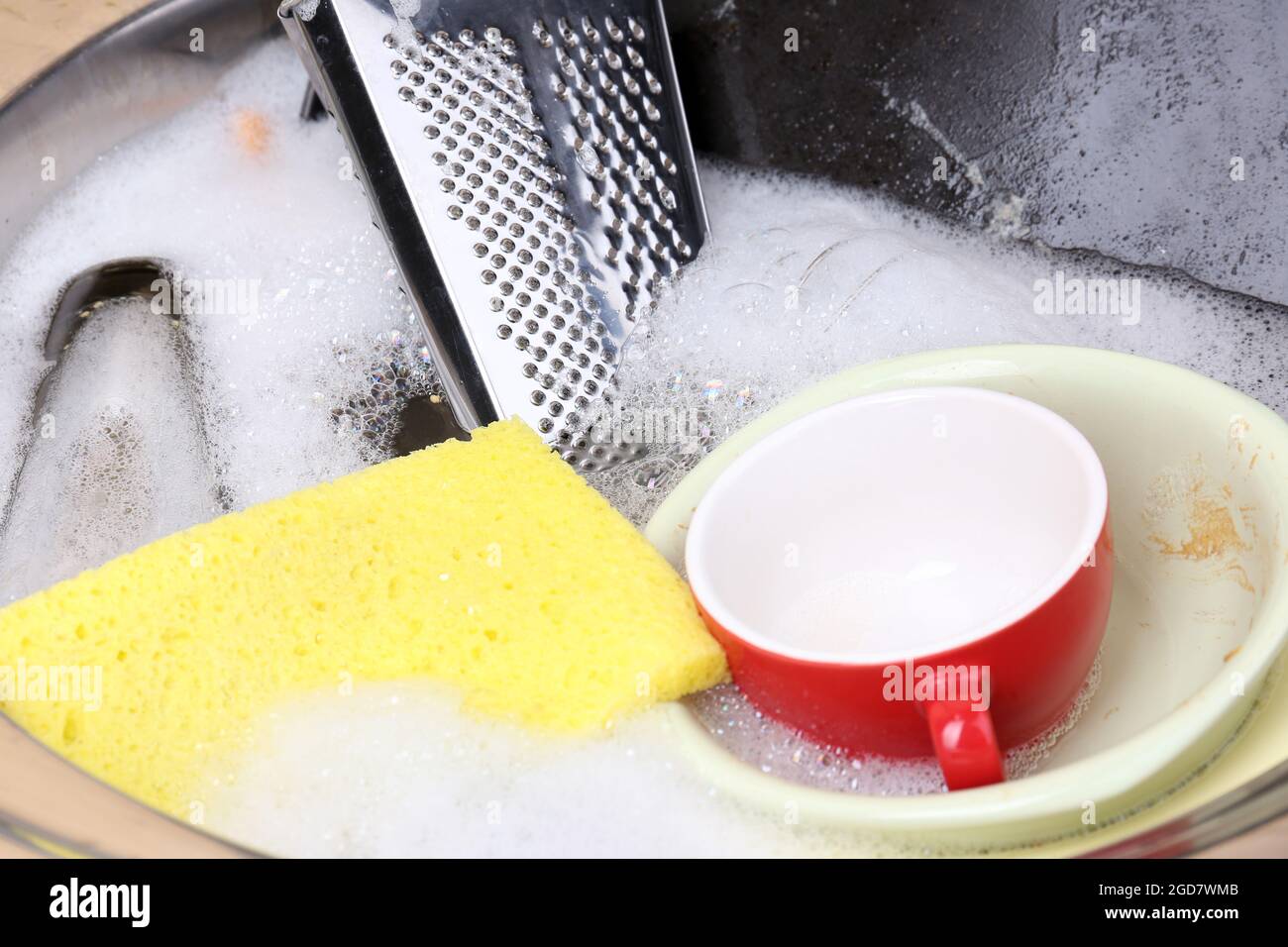 Utensils soaking in kitchen sink Stock Photo - Alamy