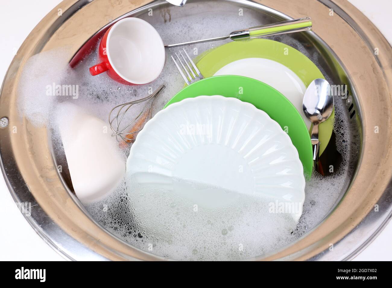Utensils soaking in kitchen sink Stock Photo - Alamy
