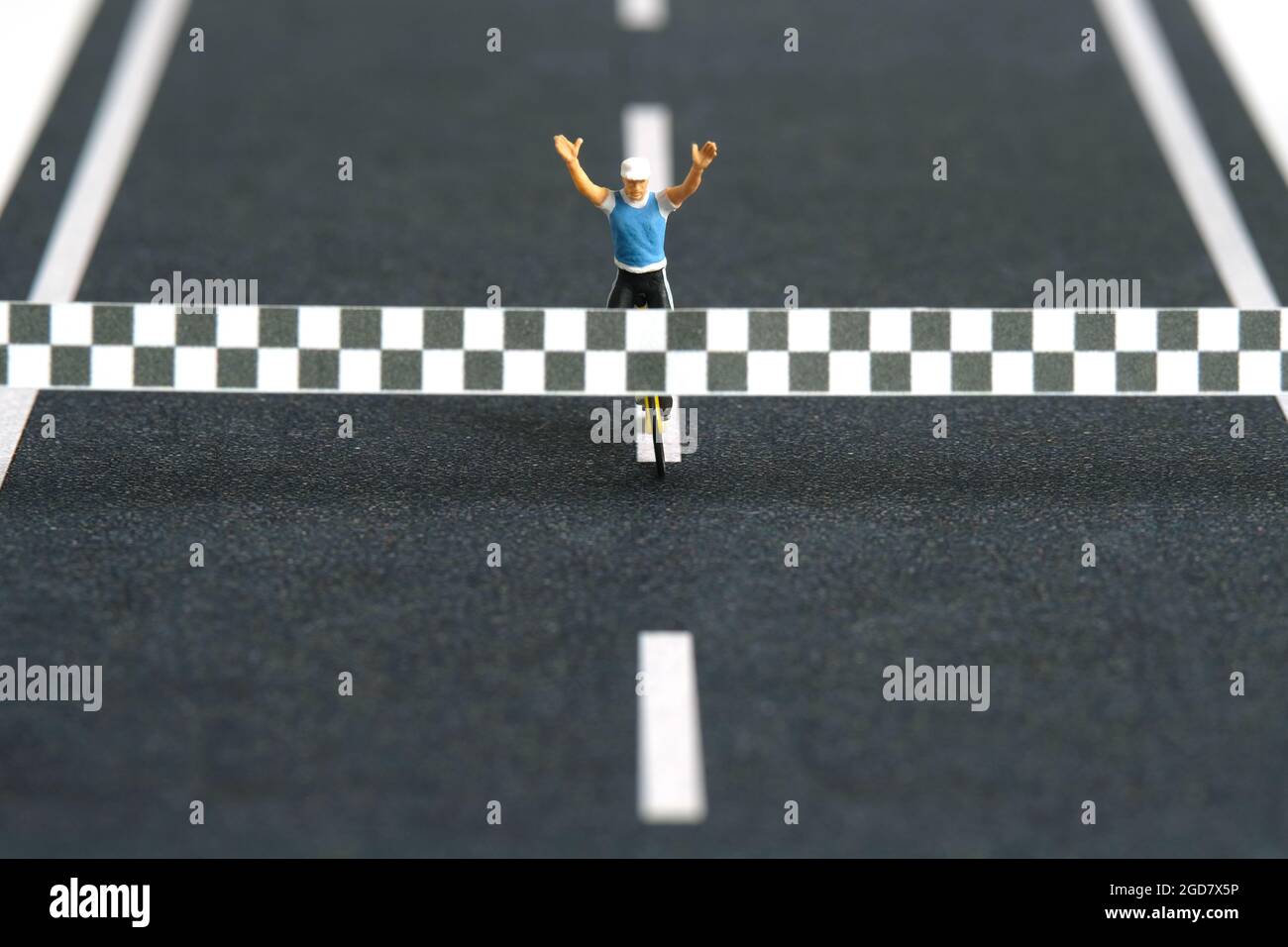Miniature people toy figure photography. A biker with finish line ...