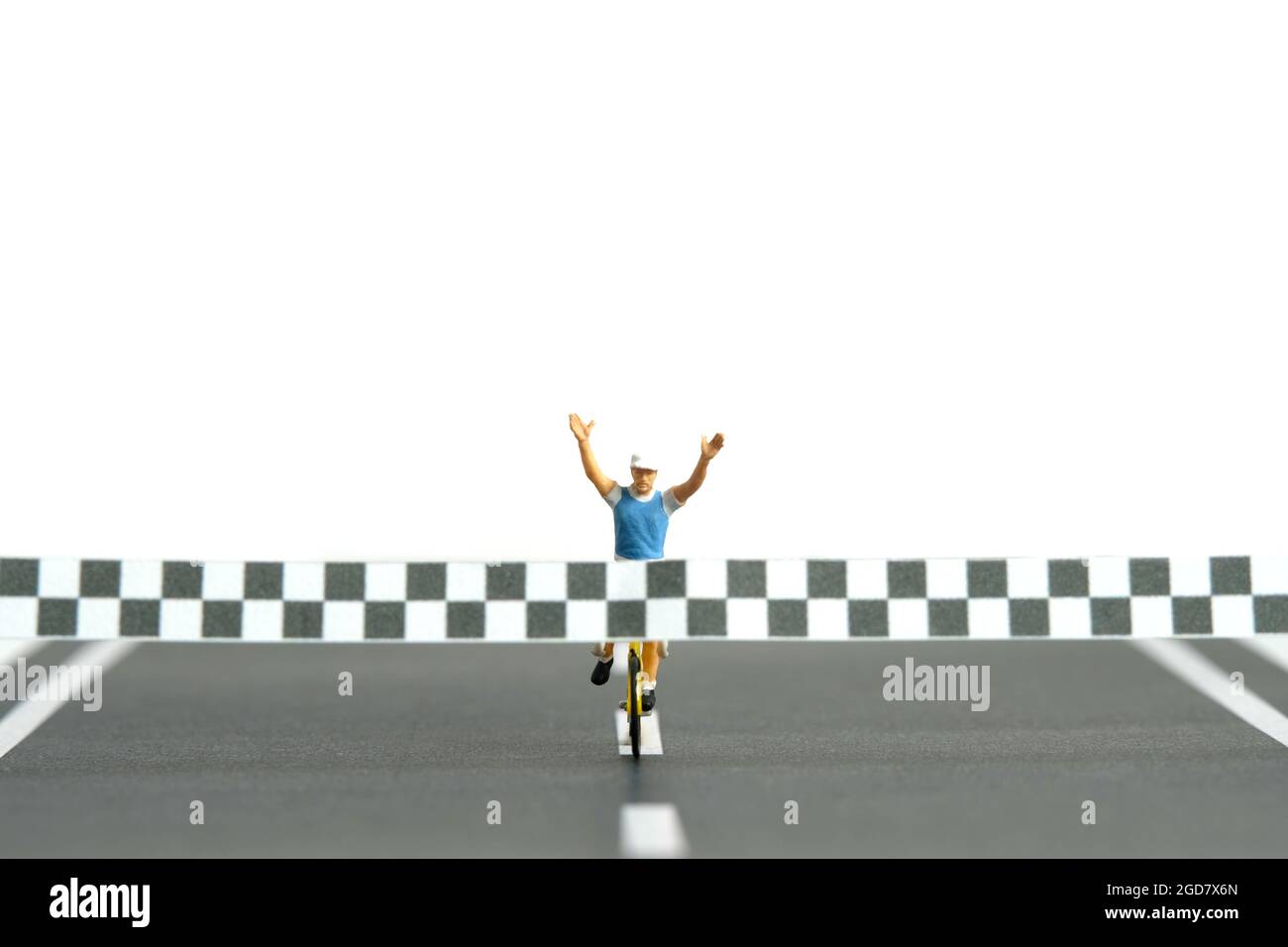 Miniature people toy figure photography. A biker with finish line ...