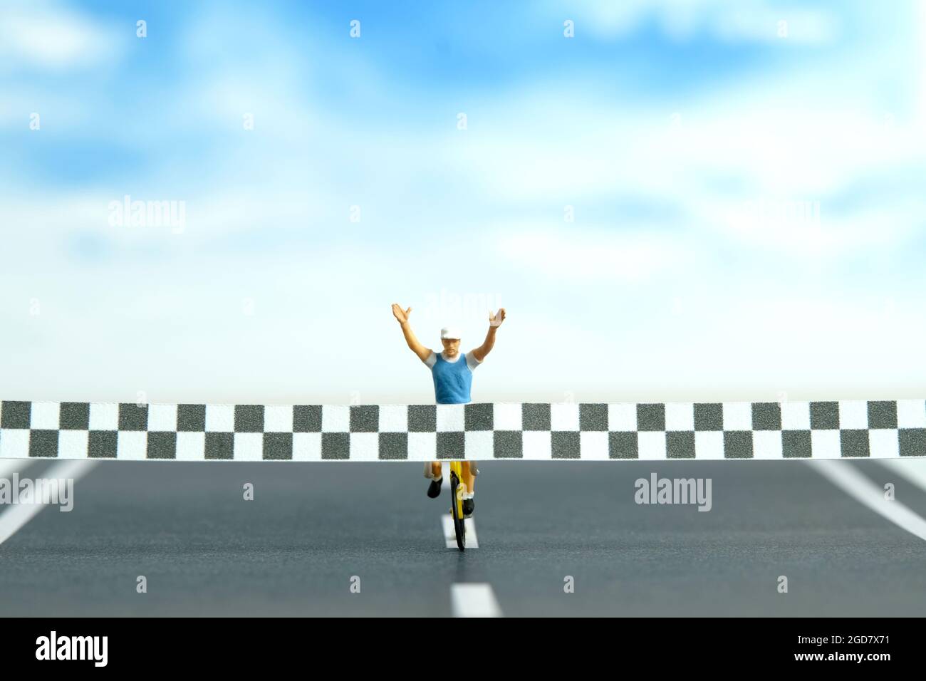 Miniature people toy figure photography. A biker with finish line ...