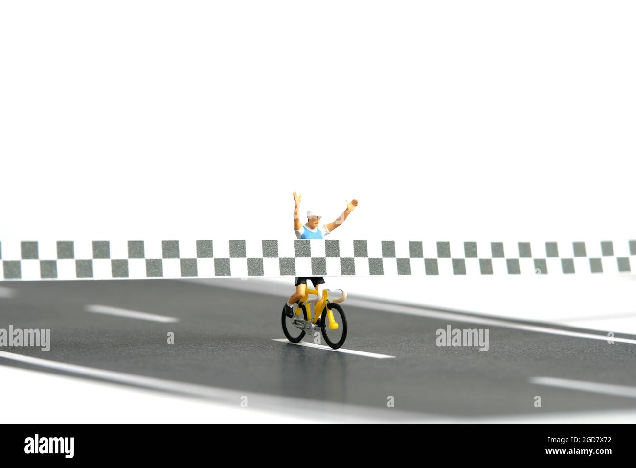 Miniature people toy figure photography. A biker with finish line ...