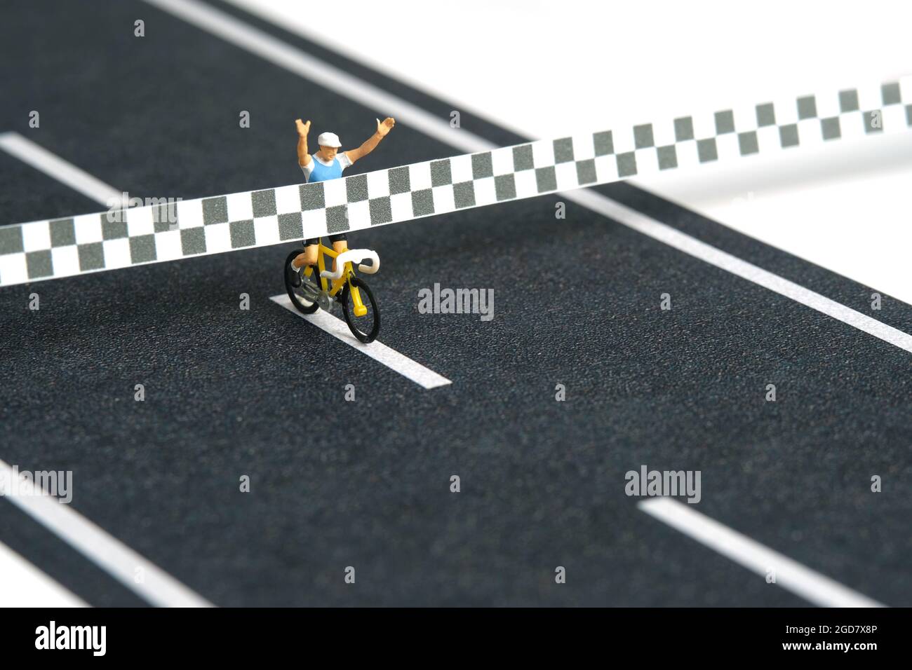Miniature people toy figure photography. A biker with finish line ...