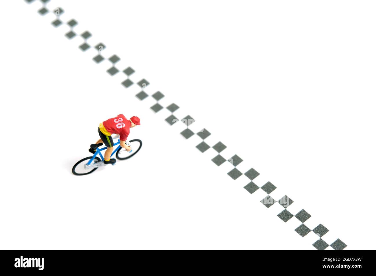 Miniature people toy figure photography. A biker with finish line ...