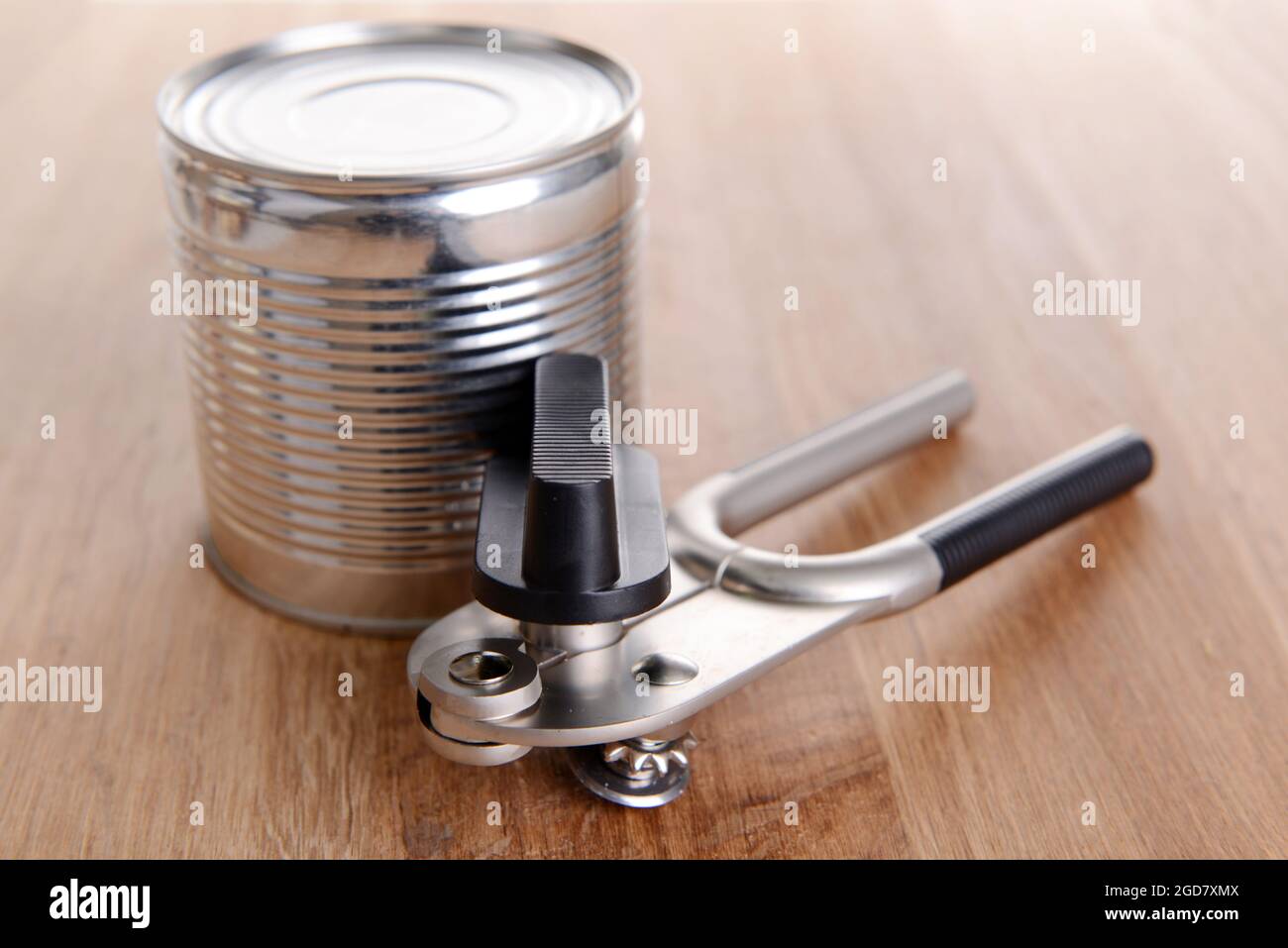 Can piercer with canned on wooden background Stock Photo - Alamy