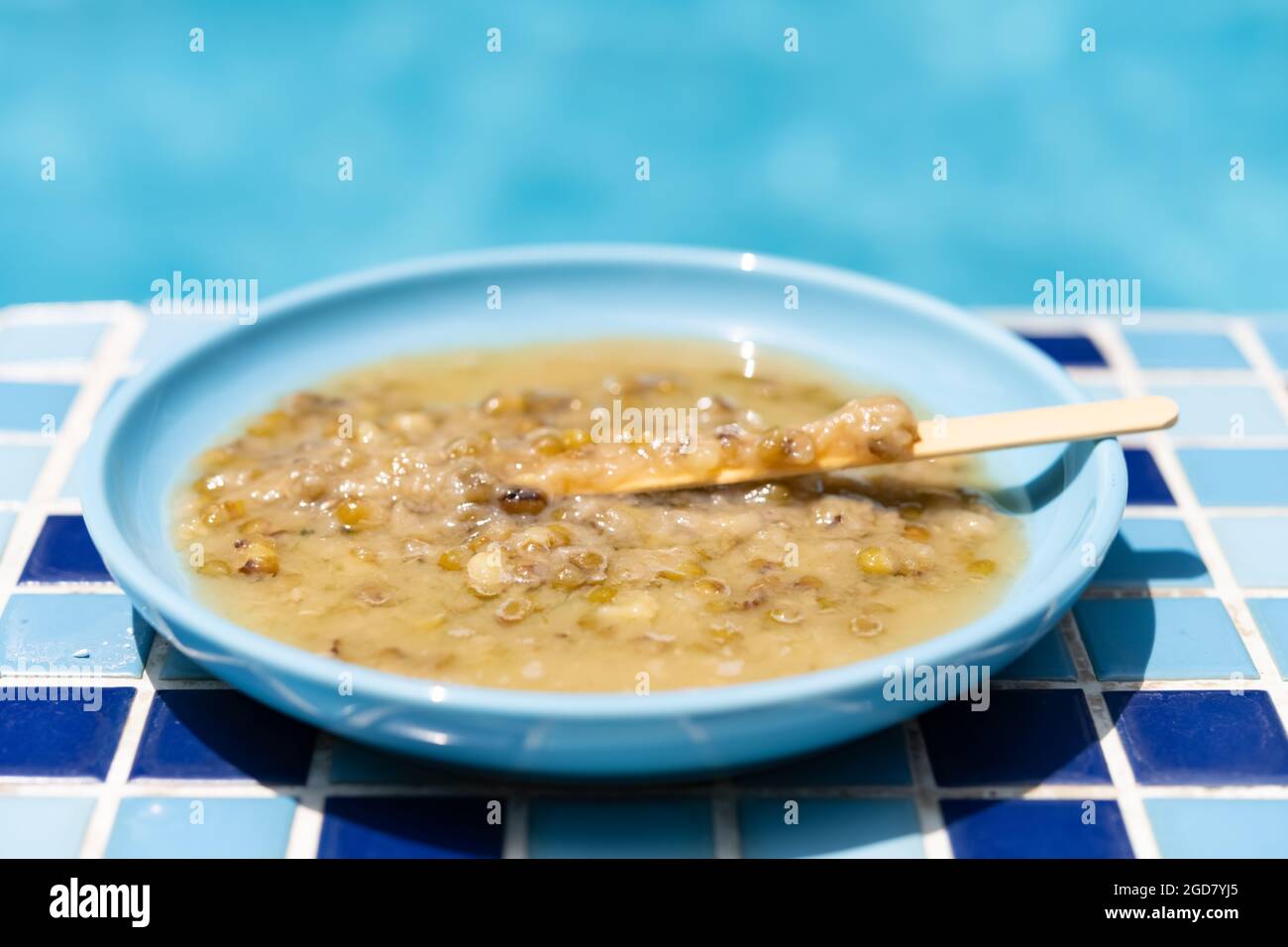 melted green bean popsicle on the edge of a swimming pool Stock Photo ...