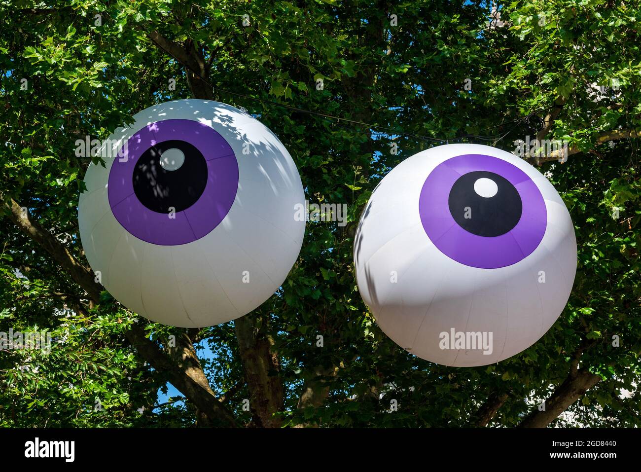 London, UK. 11th Aug, 2021. Giant inflatable googly eyes seen on a tree ...