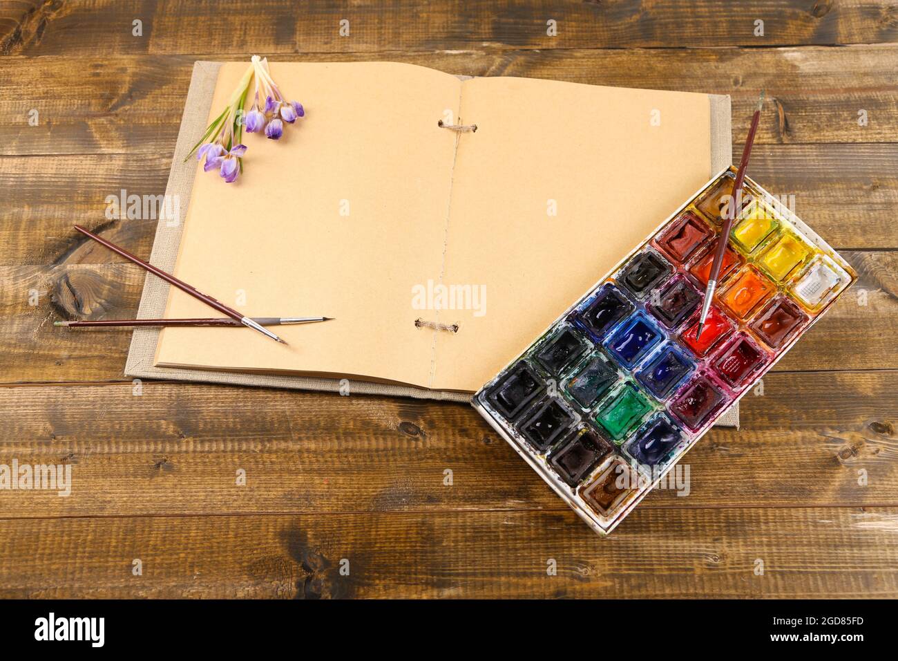 Composition with colorful watercolors, brushes and sketcher on wooden ...