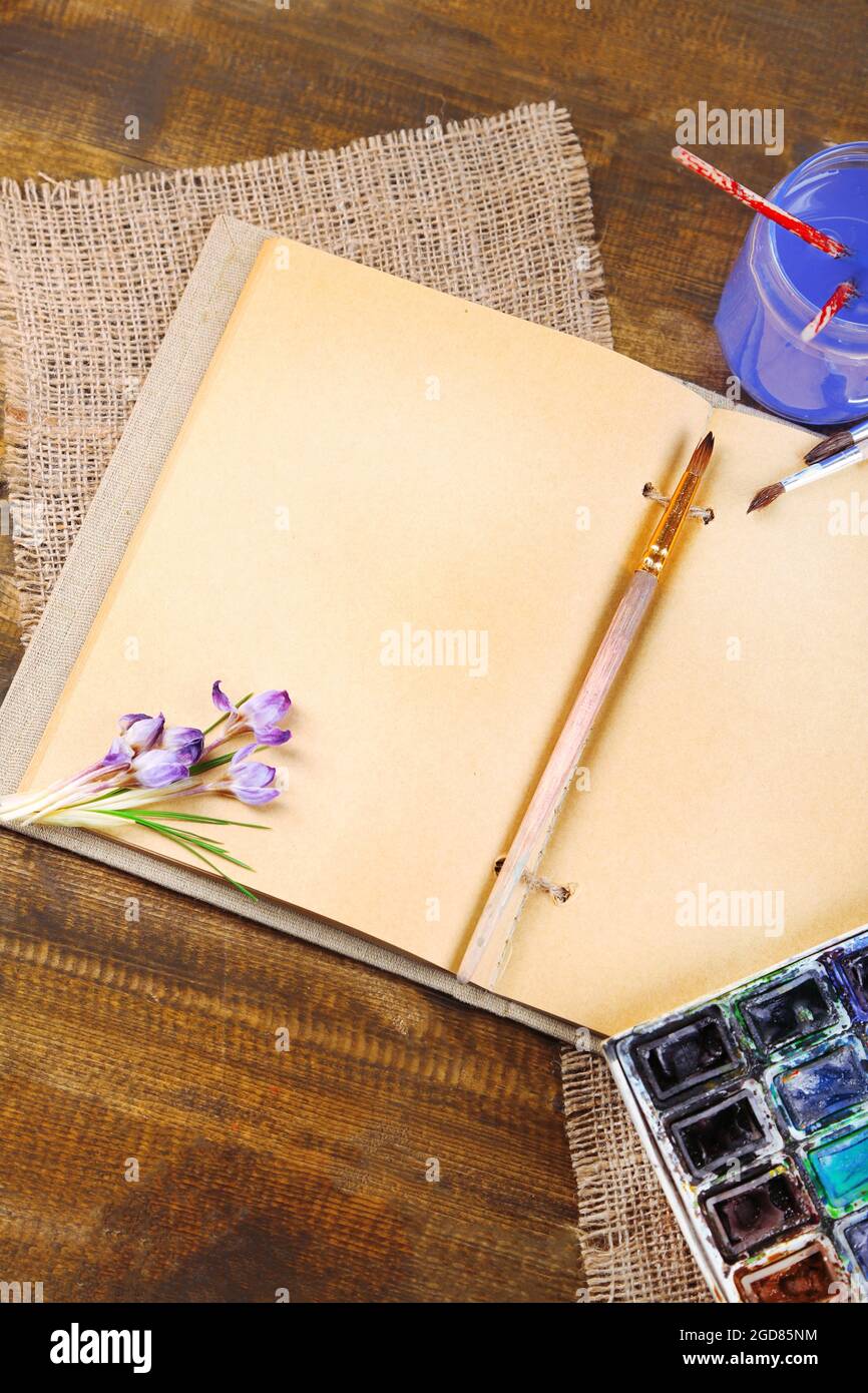 Composition with colorful watercolors, brushes and sketcher on wooden ...