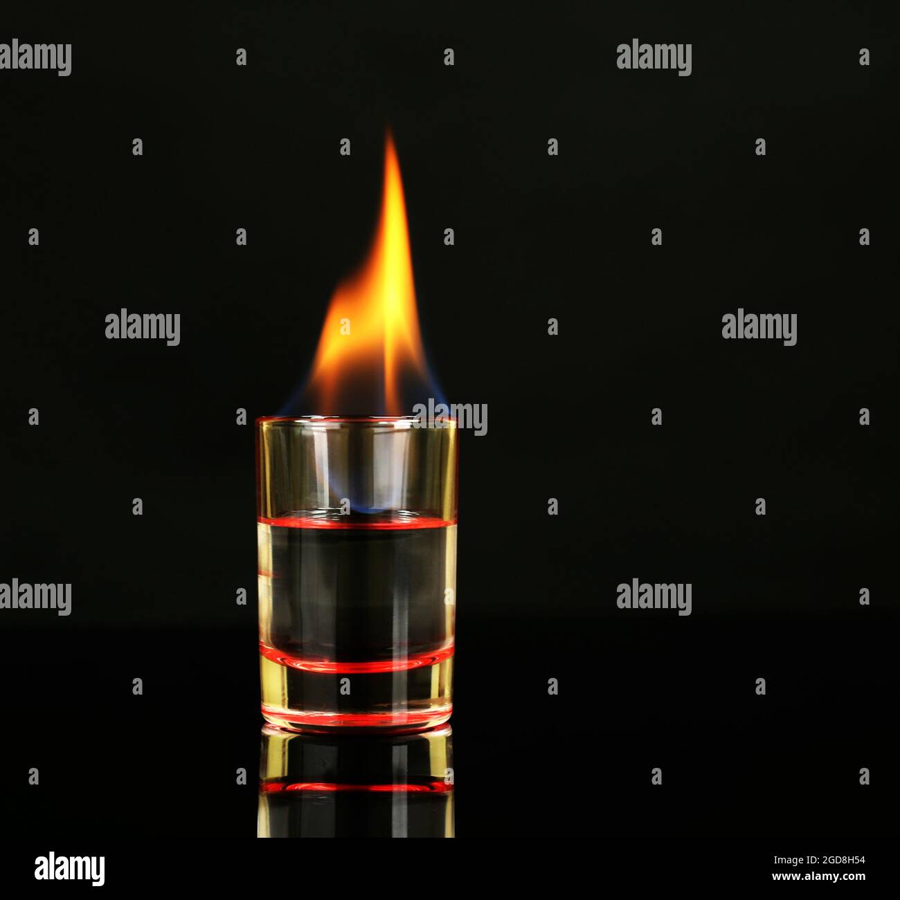 Glass with burning alcohol on black background Stock Photo - Alamy
