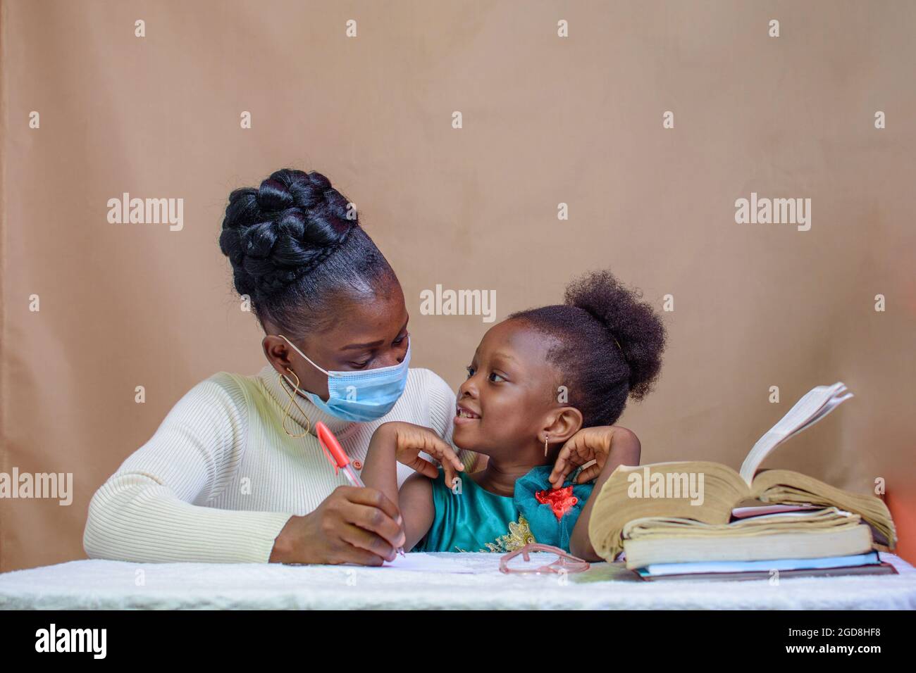 African teacher or mother wit nose mask, teaching and helping a little ...