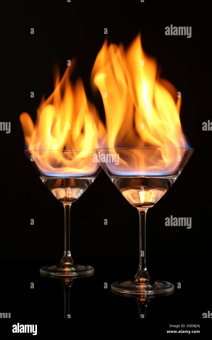 Glasses with burning alcohol on black background Stock Photo - Alamy