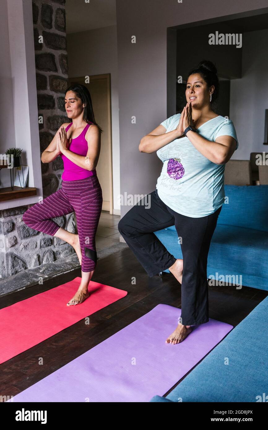 Latin women practicing yoga standing at home in Mexico City, plus size ...