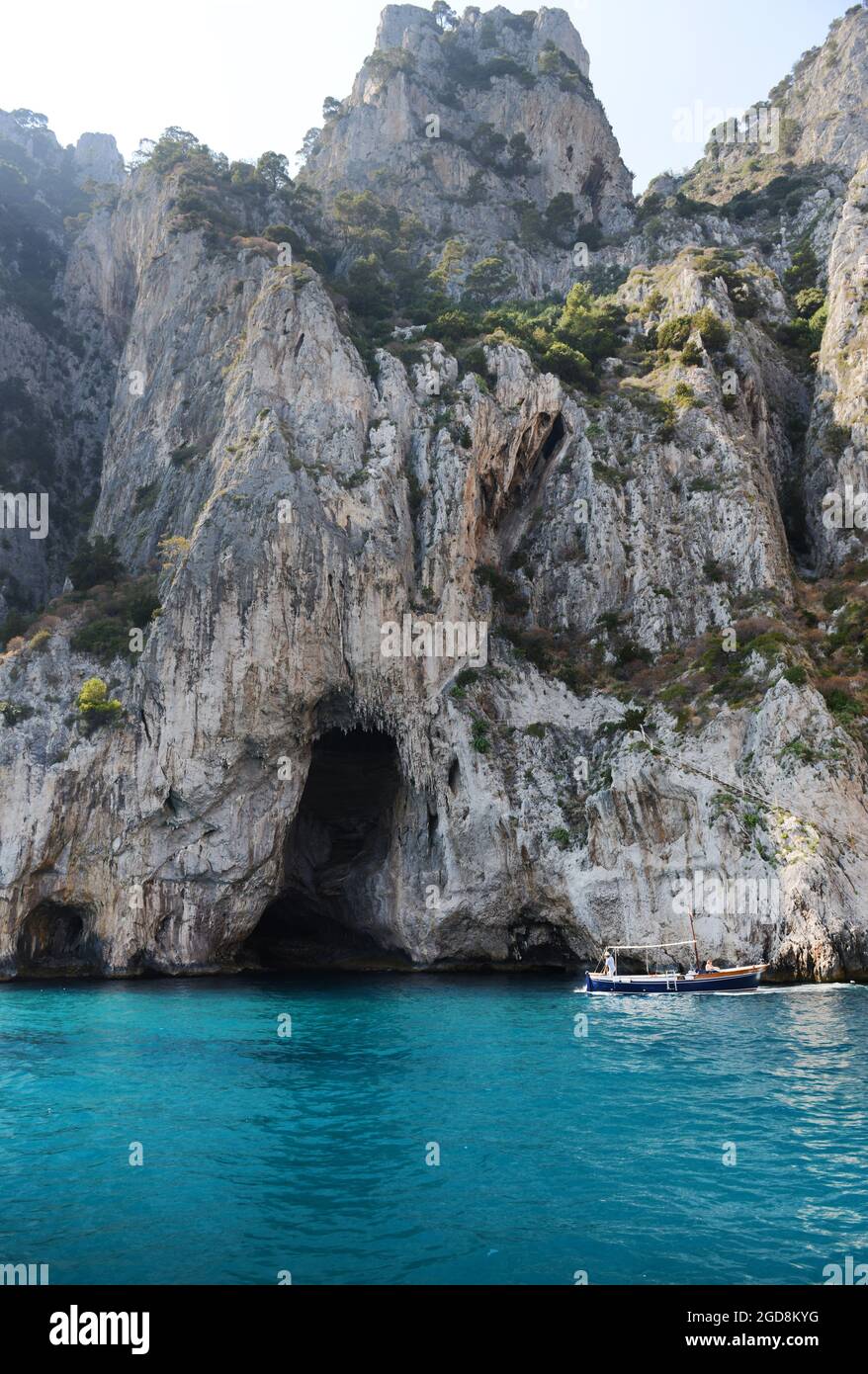 A small boat by the beautiful coastal landscapes of Capri, Italy Stock ...