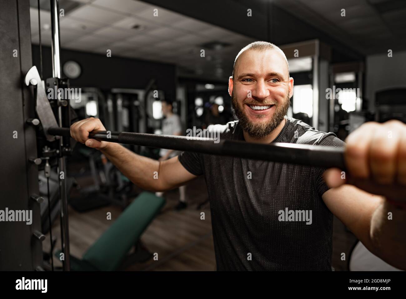 Cheerful smiling man bodybuilder standing in a gym Stock Photo - Alamy