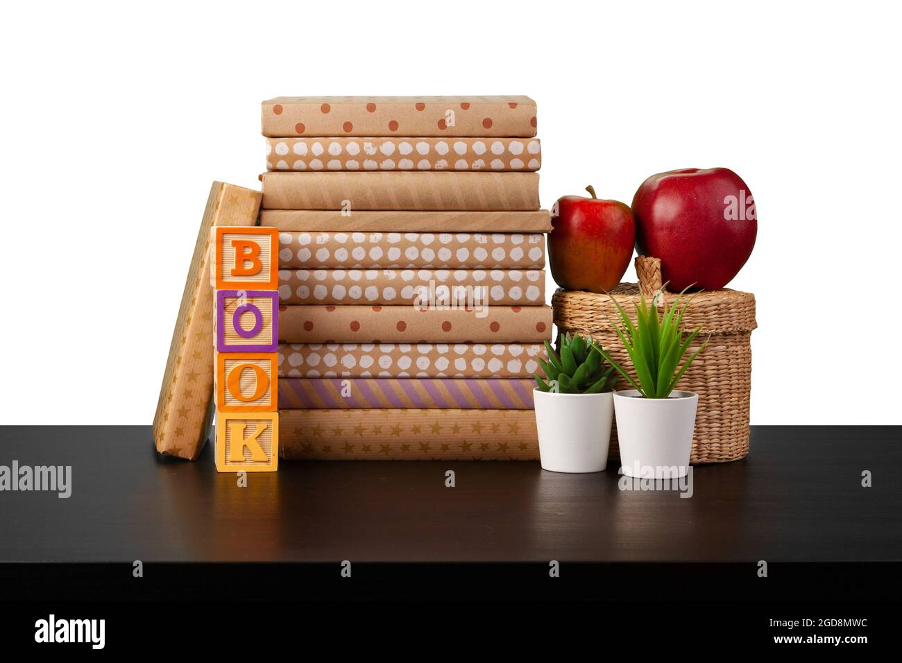 Stack of books and apple on tabletop against white background Stock ...