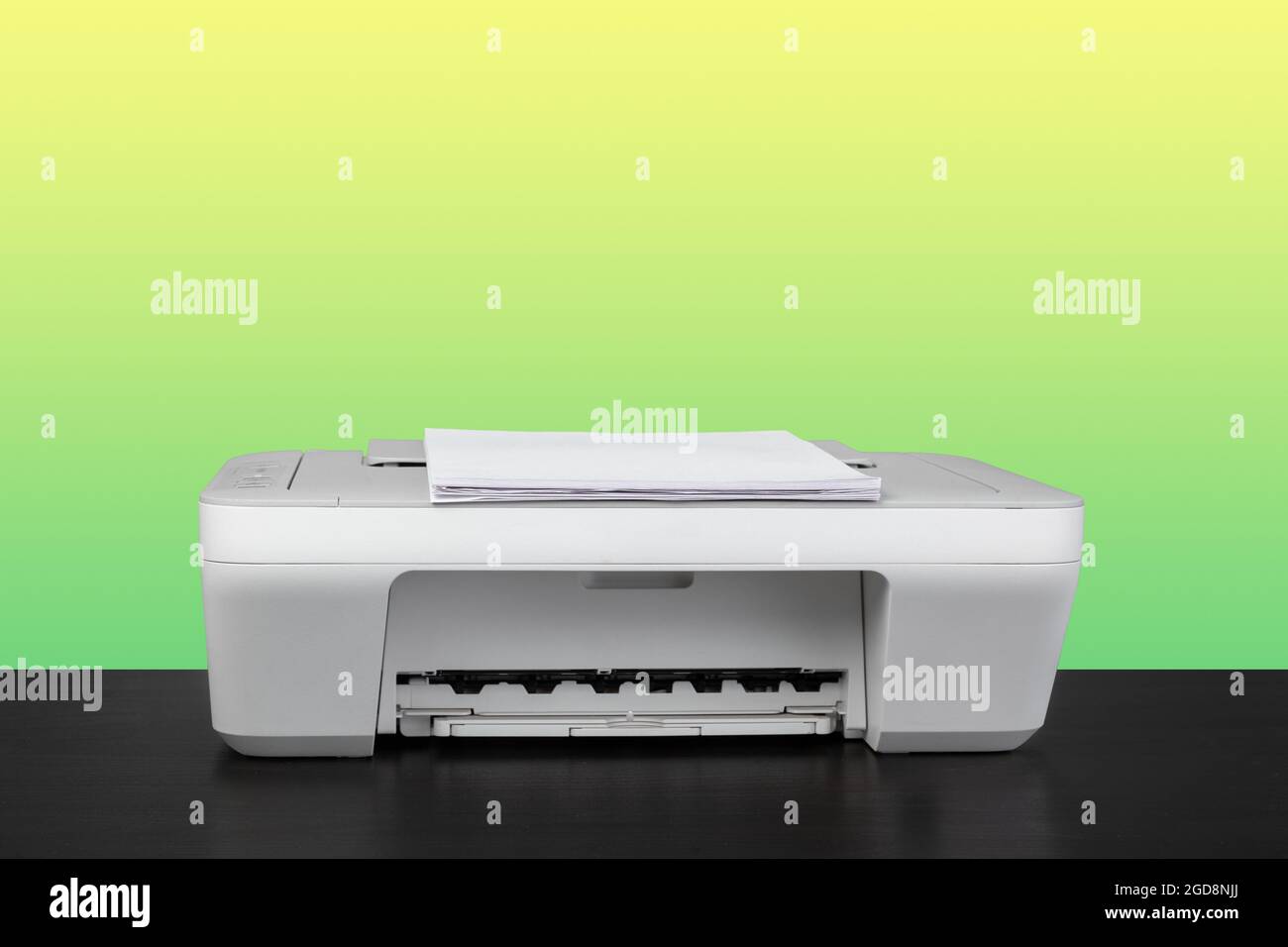 Home laser printer on desk against green background Stock Photo - Alamy