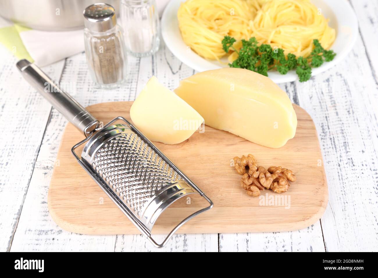 Composition with tasty spaghetti, grater, cheese, on wooden table ...