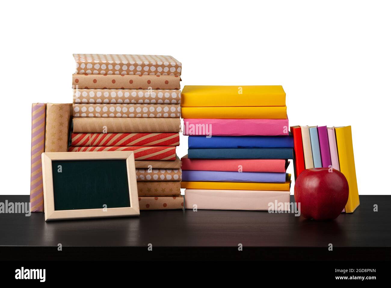 Stack of books and apple on tabletop against white background Stock ...