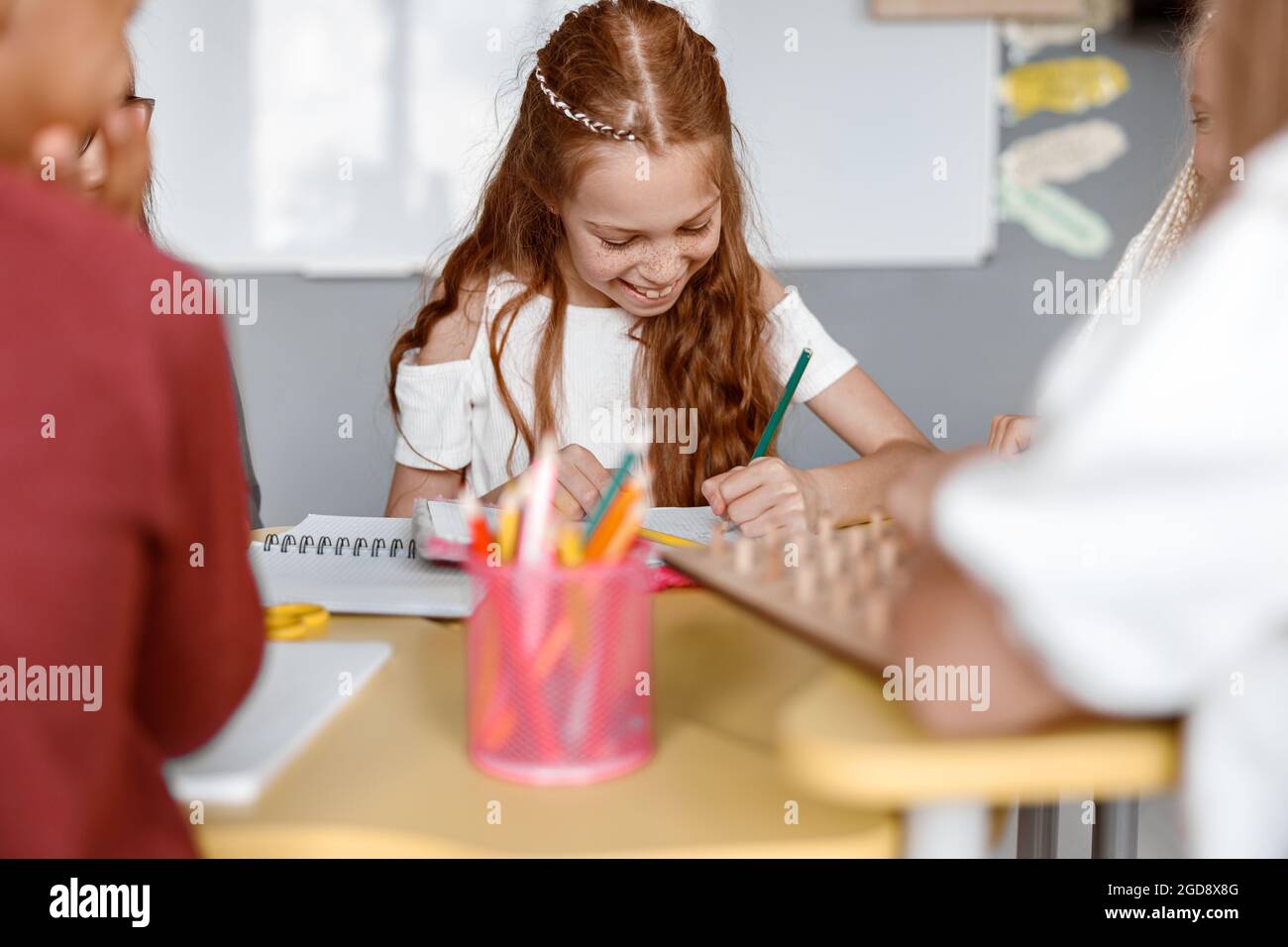 Happy girl sitting table writing hi-res stock photography and images ...