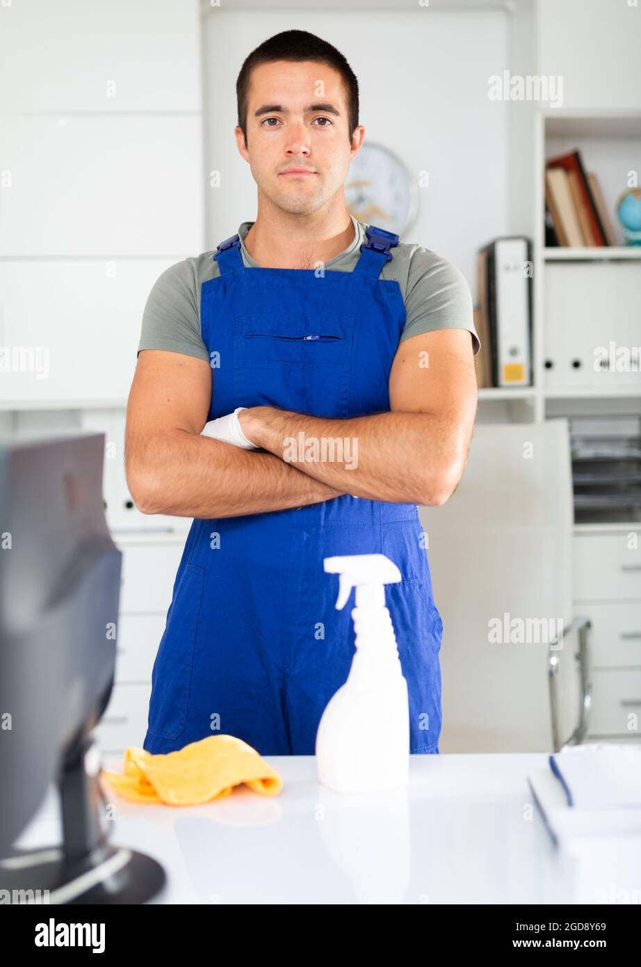 Cleaner standing in office with rag and detergent Stock Photo - Alamy
