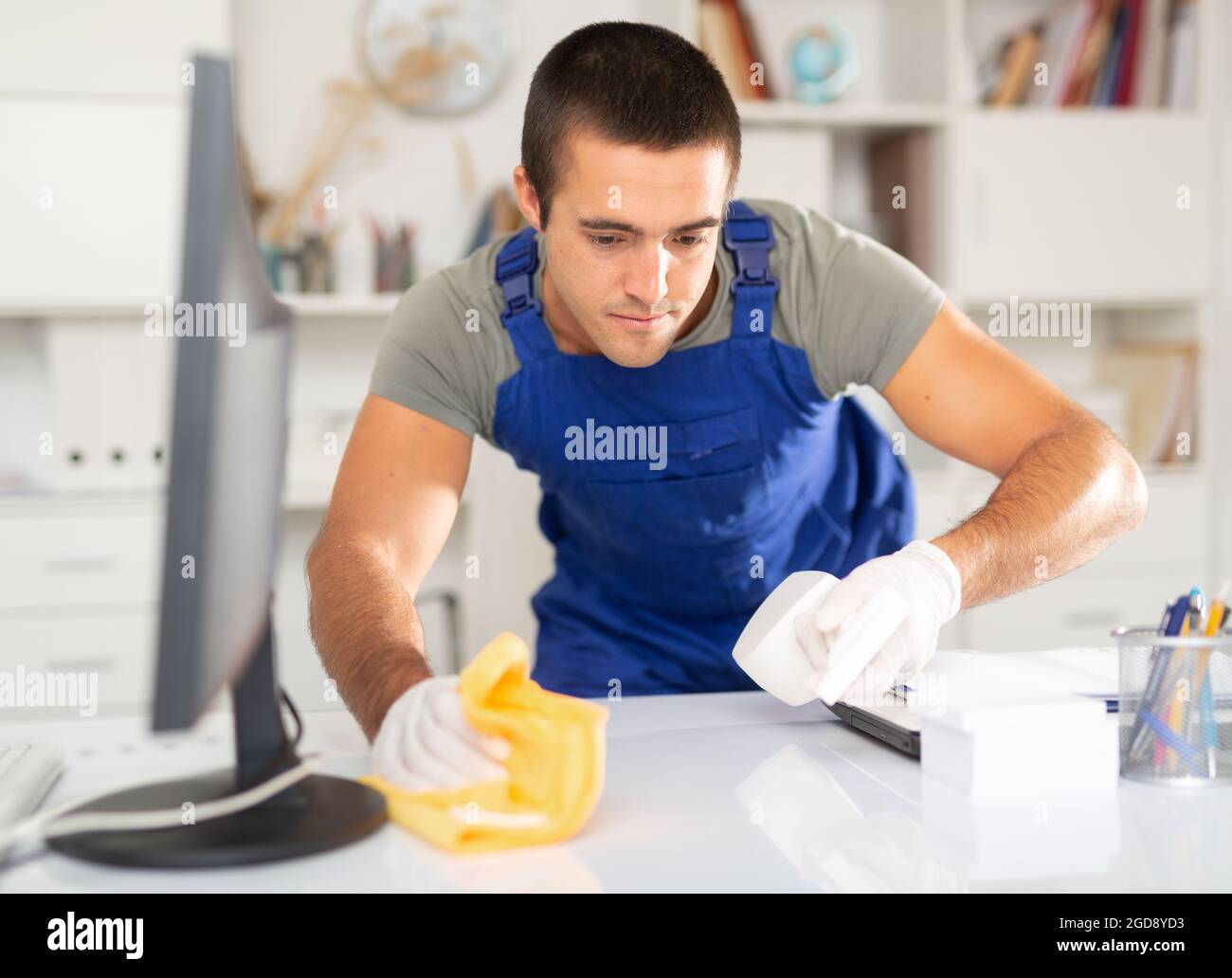 Cleaning worker wiping office desk with detergent Stock Photo - Alamy