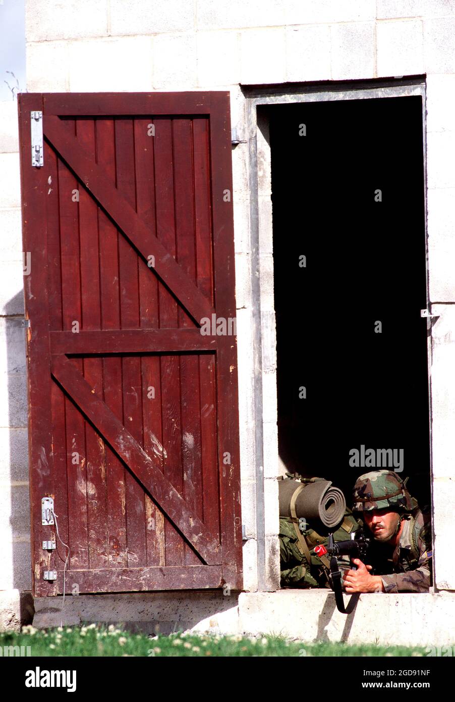A U.S. Army soldier takes cover in the doorway of an abandoned building ...