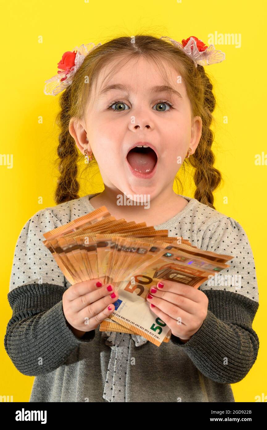 The girl is holding euro bills in denominations of 50 euros, a child ...