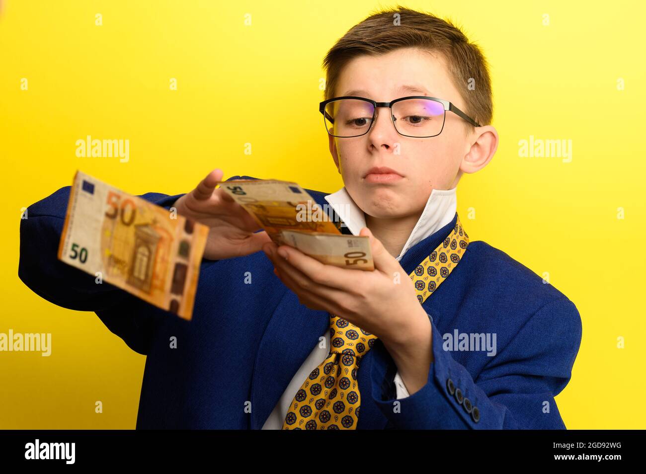 The child scatters money, a boy in a suit throws euros, a portrait of a ...