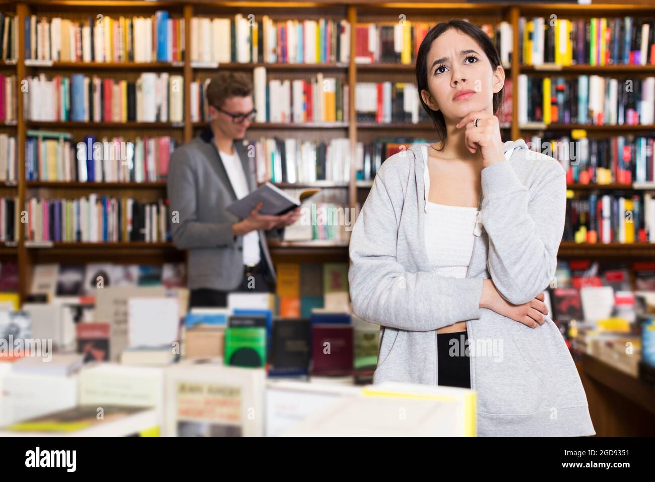 pensive girl in interior of bookstore Stock Photo - Alamy