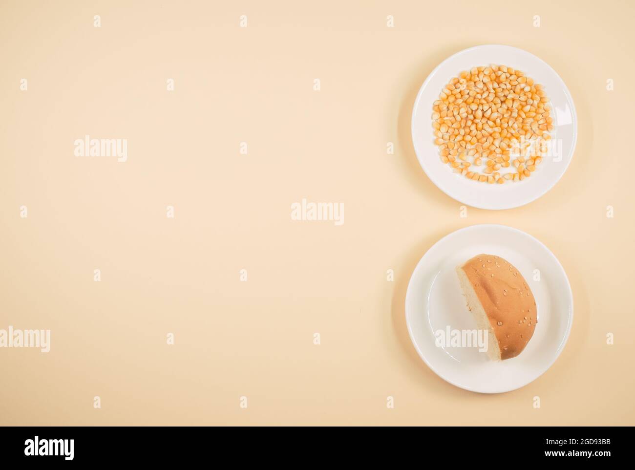 Top view of half bread bun and corn grains on a plate isolated on light ...