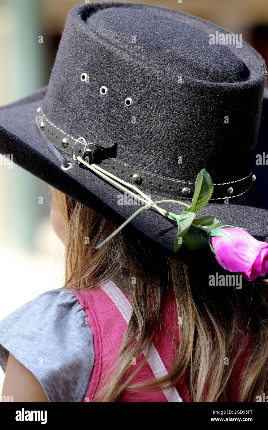 Back view of a girl with a pink rose on her black cowboy hat Stock ...
