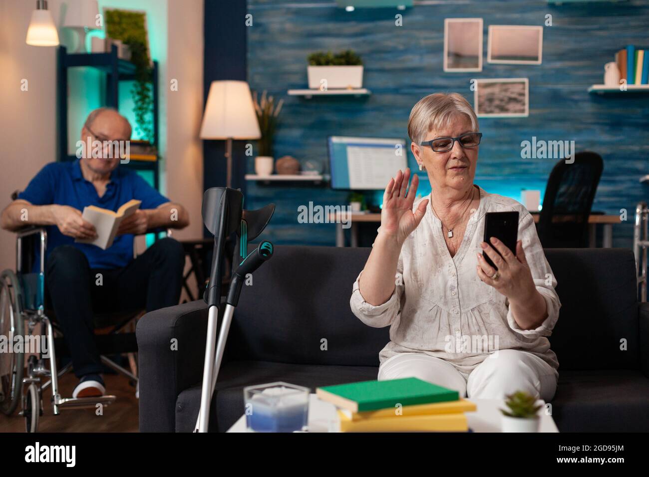 Mature retired couple on modern video call at home using smartphone ...