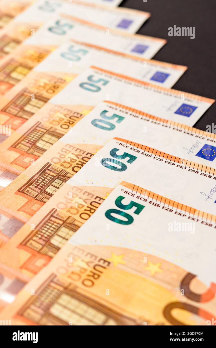 Diagonal line of euro notes isolated on black background, salary in ...